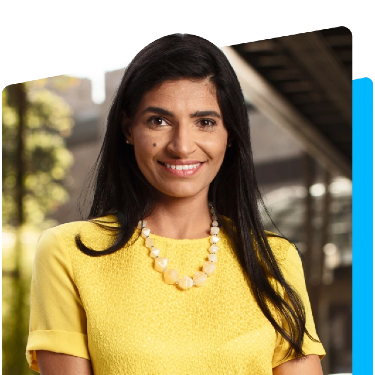 Imagem com mulher de blusa amarela sorrindo em frente ao um parque de ...