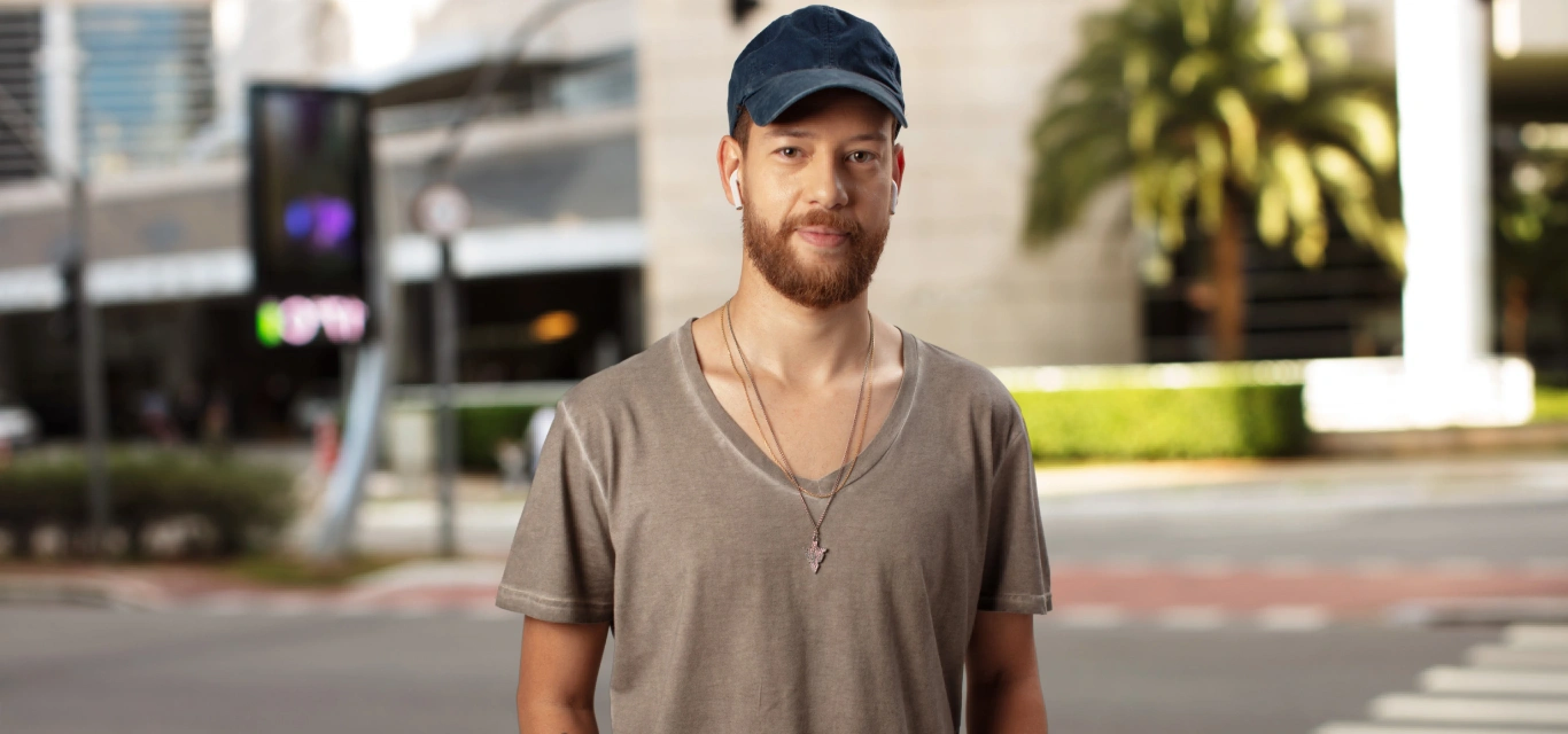 Imagem com homem na frente de uma praça com fundo desfocado